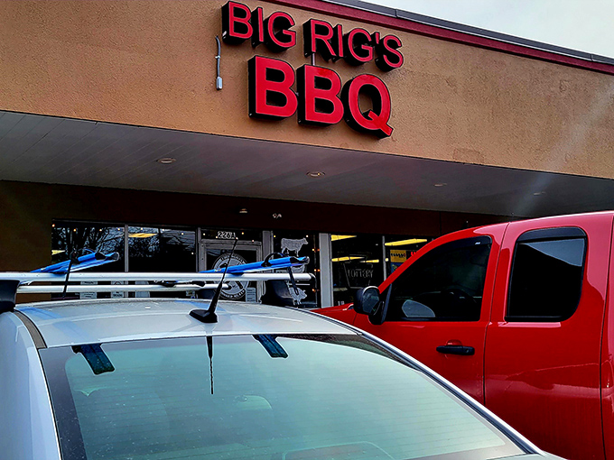 The bright red sign of Big Rig's BBQ stands out like a beacon for meat lovers, promising smoky delights within this unassuming Monroeville strip mall location.