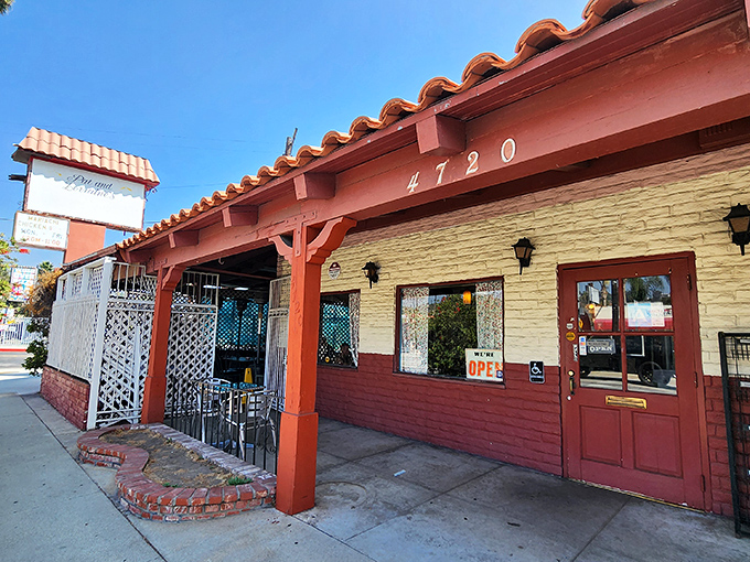 The Spanish-style exterior of Pat & Lorraine's welcomes hungry patrons with its terracotta roof and charming red door—a humble facade hiding breakfast greatness within.