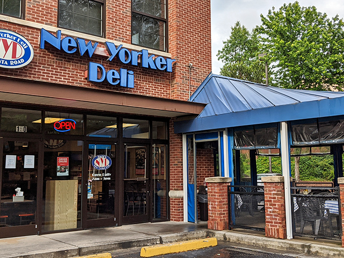 The blue awning and brick facade of Jack's New Yorker Deli stands as a beacon of sandwich salvation in Atlanta's bustling cityscape.