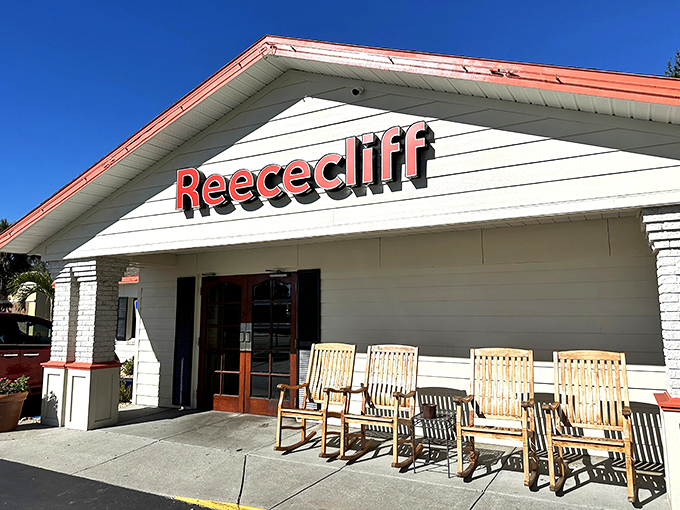The iconic white exterior with red trim and wooden rocking chairs says "slow down, friend—good food takes time."