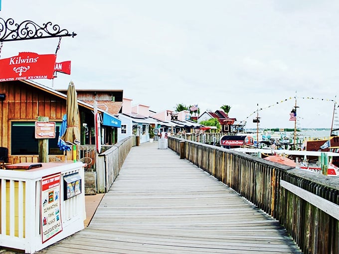 The weathered wooden boardwalk stretches into the distance, flanked by colorful shops that beckon like old friends waiting to share their stories.