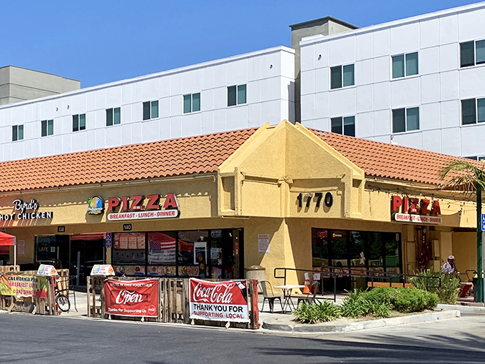 The unassuming storefront where pizza dreams come true. California Pizza Place's retro sign promises three daily opportunities for deliciousness.
