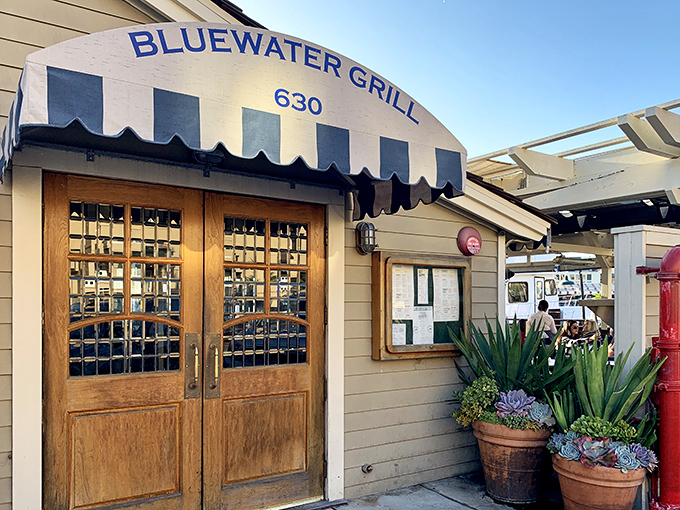The iconic blue and white awning welcomes seafood lovers like a maritime flag signaling "abandon all diets, ye who enter here."