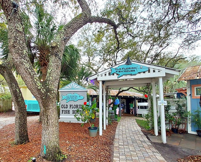 A welcoming portal to seafood paradise! The charming entrance to Old Florida Fish House beckons under ancient oaks, promising authentic coastal delights within.