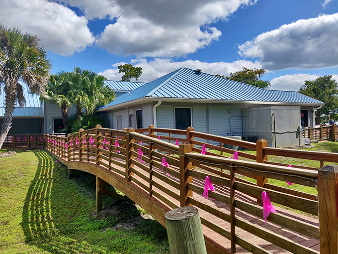 The iconic blue-roofed entrance to Corky Bell's, where a wooden bridge adorned with pink ribbons welcomes seafood pilgrims to this waterfront sanctuary.