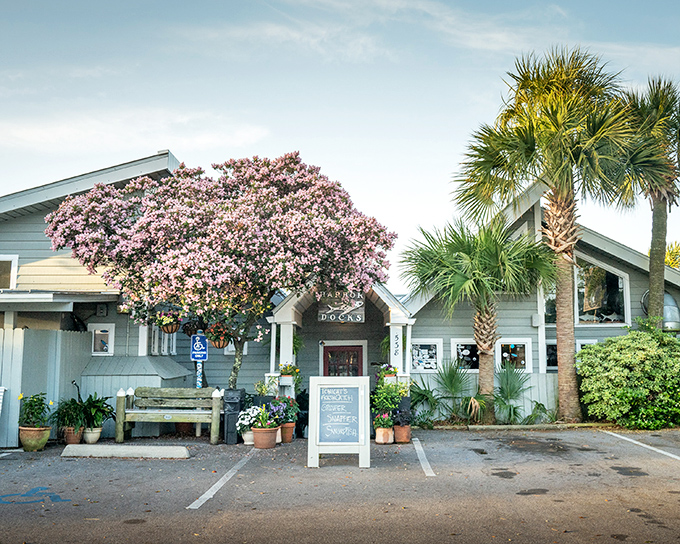 Harbor Docks welcomes you with a rustic wooden sign framed by flowering trees, like Florida's version of a seafood speakeasy hiding in plain sight.