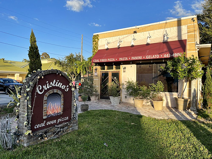 The Mediterranean dream meets Florida sunshine at Cristino's, where that iconic arched sign promises coal-fired perfection waiting just beyond those doors.
