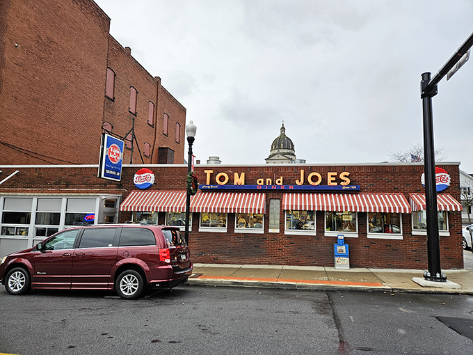 The iconic red-and-white striped awning of Tom & Joe's stands like a culinary lighthouse in downtown Altoona, beckoning hungry travelers to safe harbor.