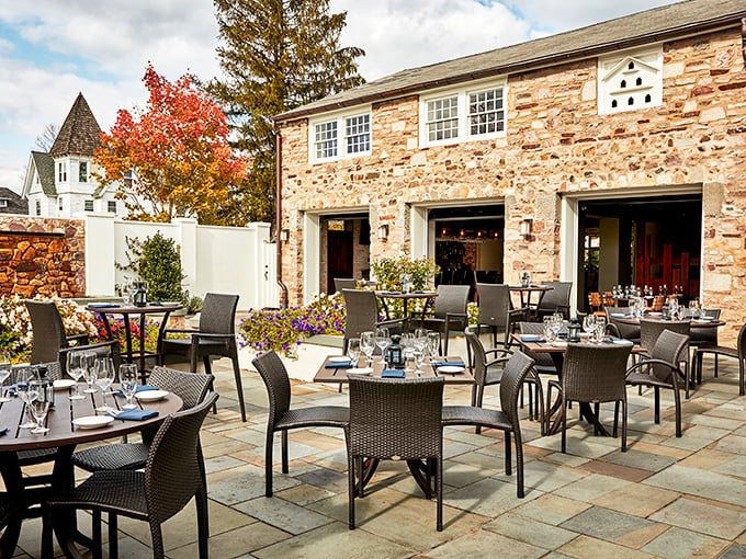 The historic Blue Bell Inn stands proudly in Pennsylvania sunshine, its stone facade and classic architecture whispering stories of countless memorable meals.