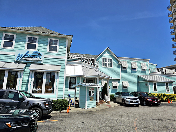 The seafoam-green exterior of Waterman's stands out like a cheerful beacon on Virginia Beach's oceanfront, promising coastal charm and seafood treasures within.