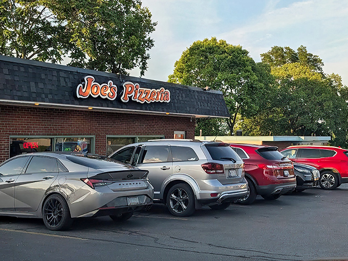 The unassuming brick exterior of Joe's Pizzeria stands as a beacon of hope for the pizza-deprived, its retro sign promising delicious salvation within. 
