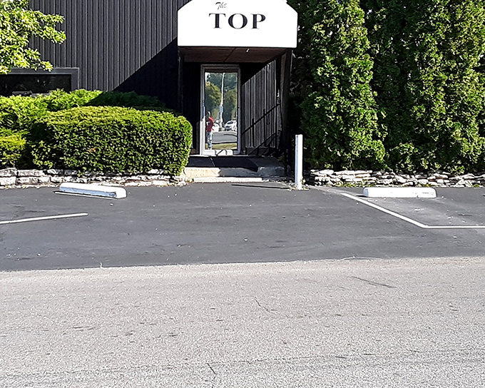 The geometric, mid-century modern entrance to The Top Steakhouse stands like a portal to another era&mdash;one where dinner was an event, not just a meal.