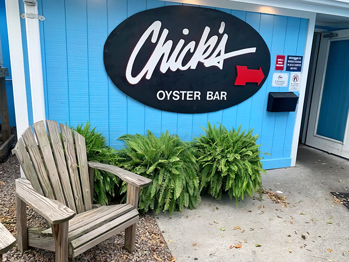 The bright blue exterior of Chick's Oyster Bar stands like a cheerful beacon on Lynnhaven Inlet, promising seafood treasures and waterfront relaxation.