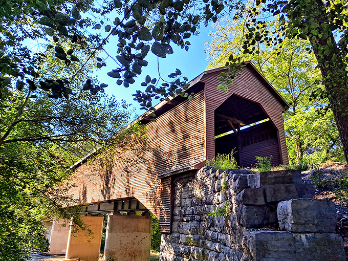 The crimson-colored Meem's Bottom Covered Bridge stands like a portal to the past, its weathered exterior perfectly framed by Virginia's lush greenery. 