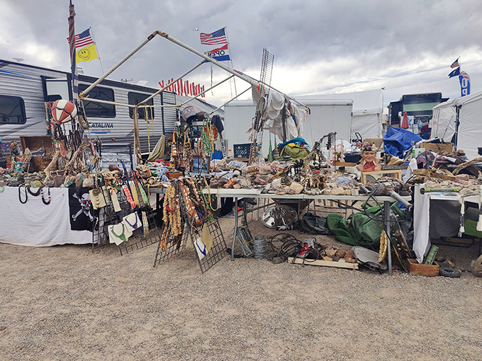 Colorful prayer flags flutter above white-clothed tables laden with treasures, creating a bazaar atmosphere where desert winds carry whispers of bargains.