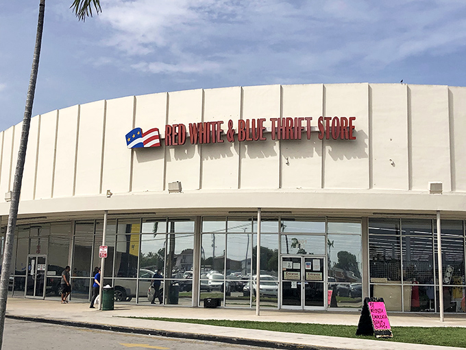 The iconic white exterior of Red White & Blue Thrift Store stands like a retail fortress against the Florida sky, promising treasures within.
