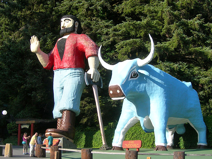 The ultimate odd couple of American folklore: Paul Bunyan waves hello while Babe the Blue Ox stands stoically beside him, surrounded by towering redwoods.