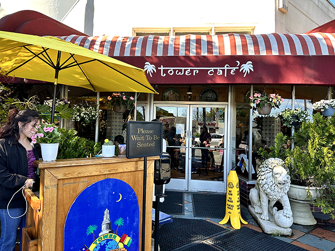 Welcome to flavor paradise! Tower Caf&eacute;'s vibrant exterior with its distinctive red awning and lush greenery promises an escape from ordinary breakfast experiences.
