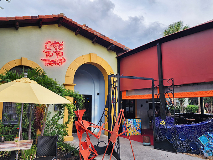 The vibrant exterior of Caf&eacute; Tu Tu Tango beckons with its Spanish-inspired architecture and neon signage &ndash; like a colorful oasis in Orlando's tourist corridor.
