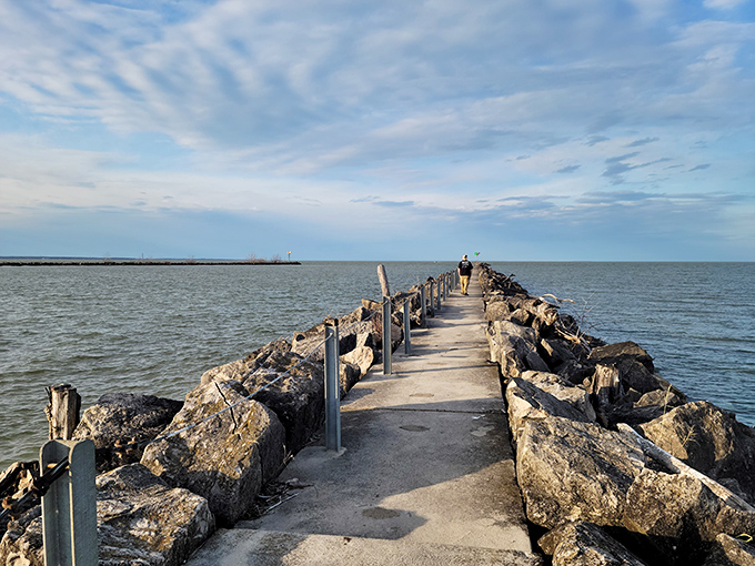 The stone breakwater stretches into Lake Erie like nature's runway, inviting visitors to stroll between two worlds of rippling blue.