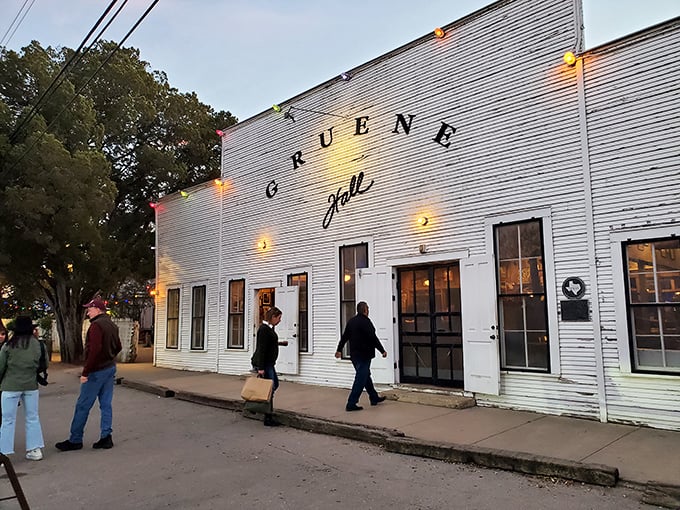 The weathered white clapboard exterior of Gruene Hall glows at dusk, like a beacon calling home wandering Texas souls seeking authentic music and cold beer.
