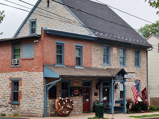 The historic stone and brick facade of Julius Sturgis Pretzel Bakery stands as a testament to American ingenuity, complete with an oversized pretzel sculpture that practically beckons you inside.