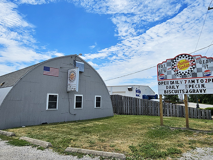 The unassuming Quonset hut exterior of Charlie Parker's Diner stands as a time capsule from post-WWII America, complete with that iconic red door beckoning hungry travelers.