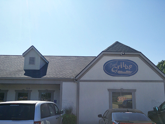 The welcoming facade of Canal Grille beckons like an old friend, complete with corrugated metal porch and that iconic blue sign promising culinary delights within.