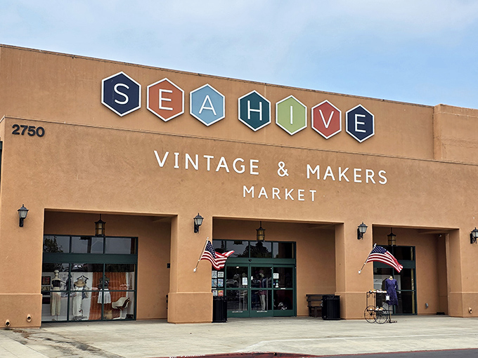 The desert-hued exterior of Sea Hive Station beckons with colorful hexagonal signage, promising treasures that'll make your car's suspension beg for mercy.