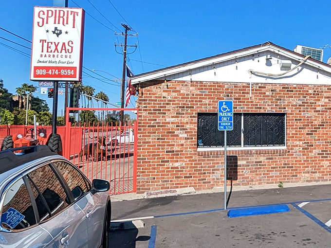 The unassuming brick exterior with its bright red gate is like a portal to barbecue nirvana &ndash; no fancy frills, just smoky promises.