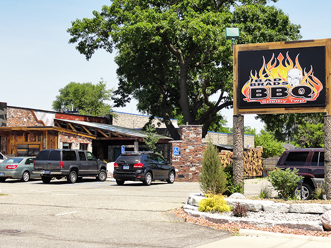 The rustic exterior of Bad Brad's BBQ beckons like a smoke signal to hungry travelers. Wood stacks and stone accents promise authentic barbecue magic within.