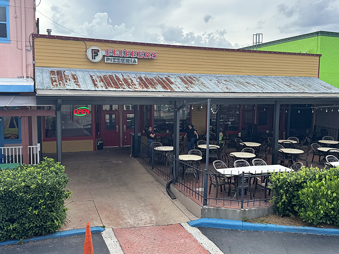 The unassuming yellow facade of Flippers Pizza in Old Town Kissimmee proves once again that pizza paradise often hides in plain sight.