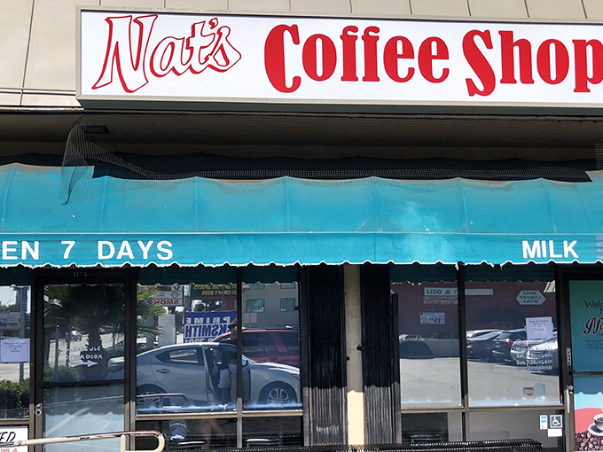 The unassuming exterior of Nat's Early Bite &ndash; where breakfast dreams come true behind a modest teal awning and zero pretension.