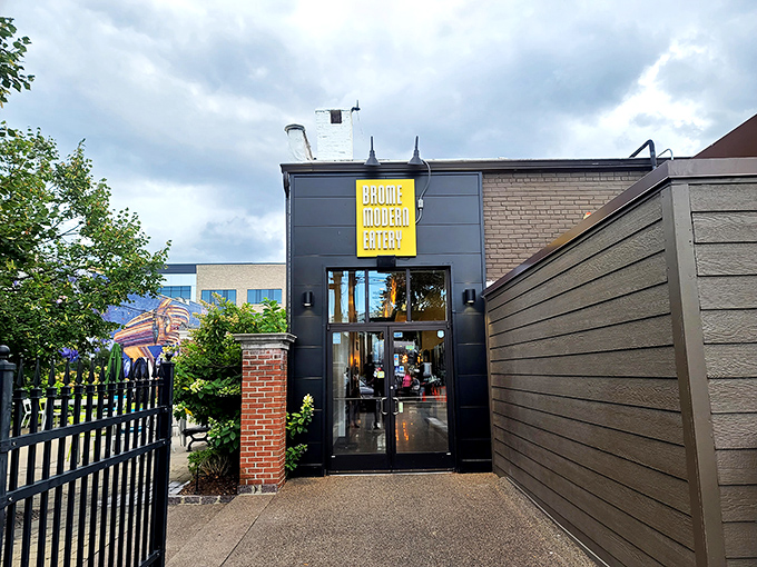 The sleek exterior of Brome Modern Eatery beckons with its bold yellow signage against dark walls&mdash;like a culinary lighthouse guiding hungry Michiganders home.