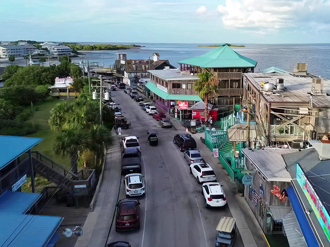 Paradise found: A pristine stretch of white sand beach meets the turquoise Gulf waters, with bright orange kayaks waiting for their next adventure.
