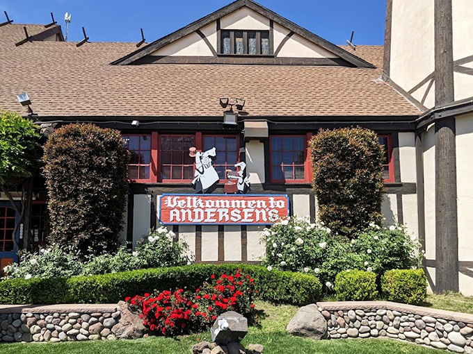 The iconic Tudor-style facade of Pea Soup Andersen's welcomes travelers with its charming "Velkommen" sign and colorful landscaping.