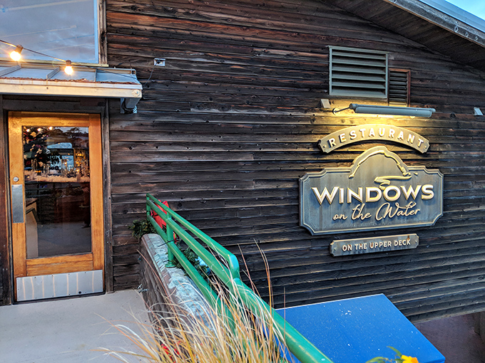 The weathered wooden exterior of Windows on the Water stands like a salty sea captain, promising treasures from the deep within.