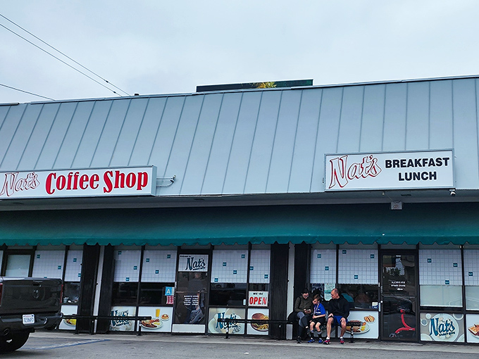 The unassuming exterior of Nat's Early Bite &ndash; where breakfast dreams come true behind a modest teal awning and zero pretension.