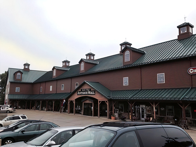 The grand barn-like exterior of Berlin Village Antique Mall stands as a beacon for treasure hunters, its distinctive green roof and cupolas promising adventures within.