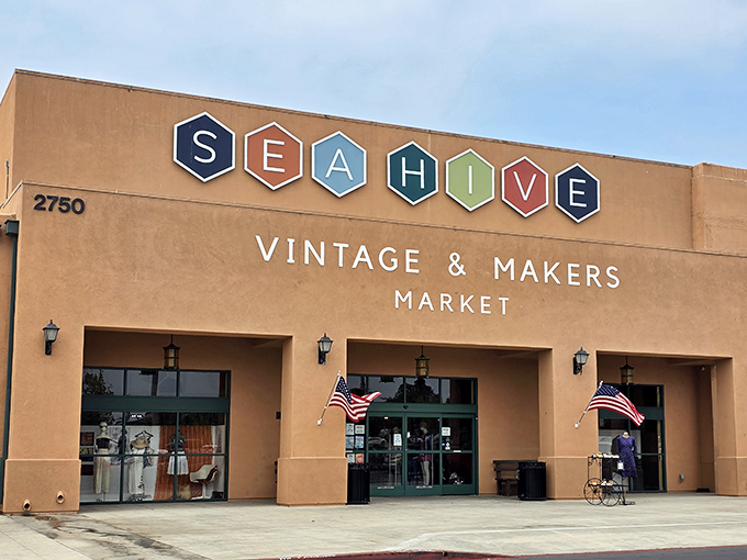 The desert-hued exterior of Sea Hive Station beckons with colorful hexagonal signage, promising treasures that'll make your car's suspension beg for mercy.