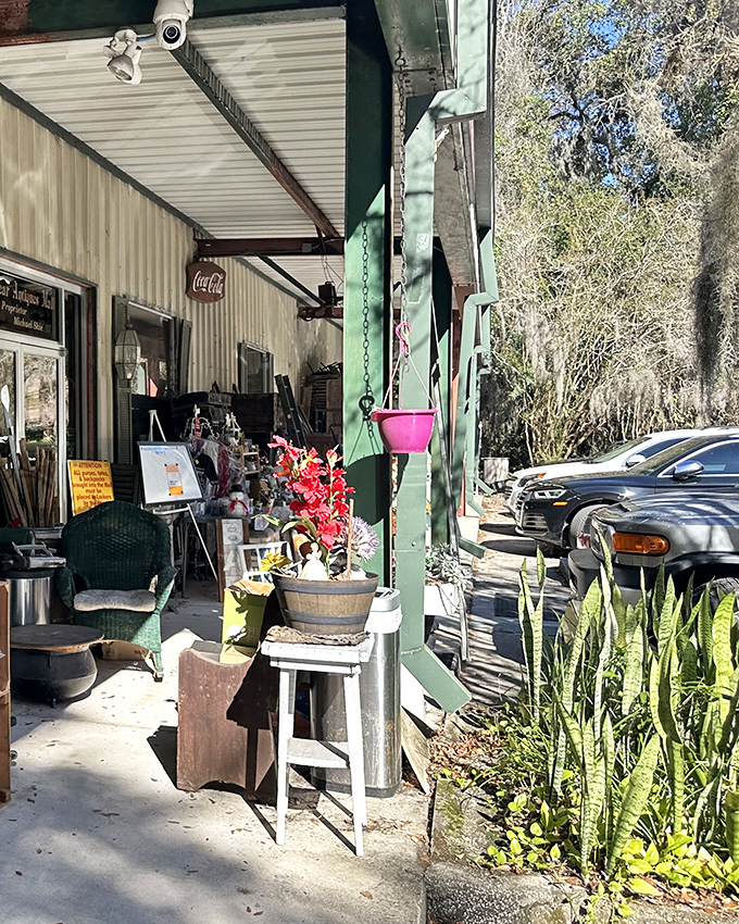 The unassuming entrance to Sugar Bear Antique Mall beckons with vintage charm. Green posts, potted plants, and a welcoming porch hint at treasures waiting just inside.