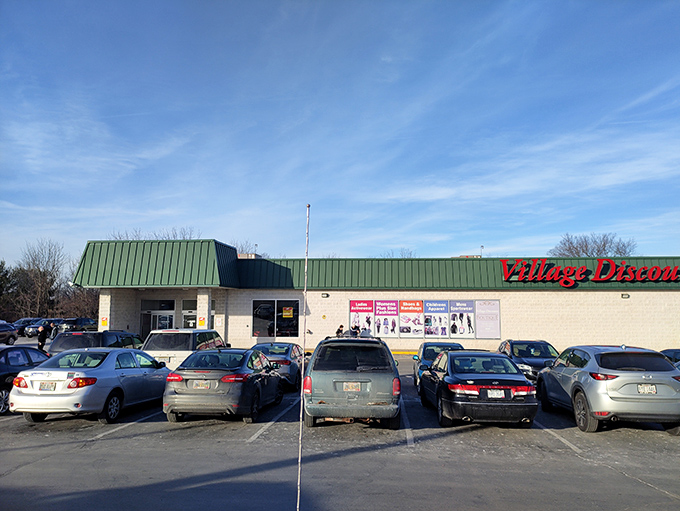 The unassuming exterior of Village Discount Outlet in Akron, where treasure hunters' dreams come true beneath that iconic green roof.