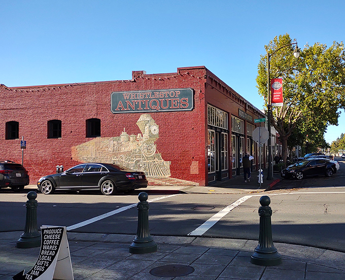 The iconic red brick facade of Whistlestop Antiques, complete with its painted locomotive mural, stands as Santa Rosa's portal to the past.
