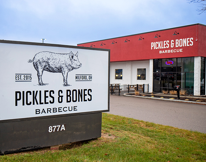 The bright red exterior of Pickles & Bones stands like a barbecue beacon in Milford, promising smoky delights within. That pig knows what's up.