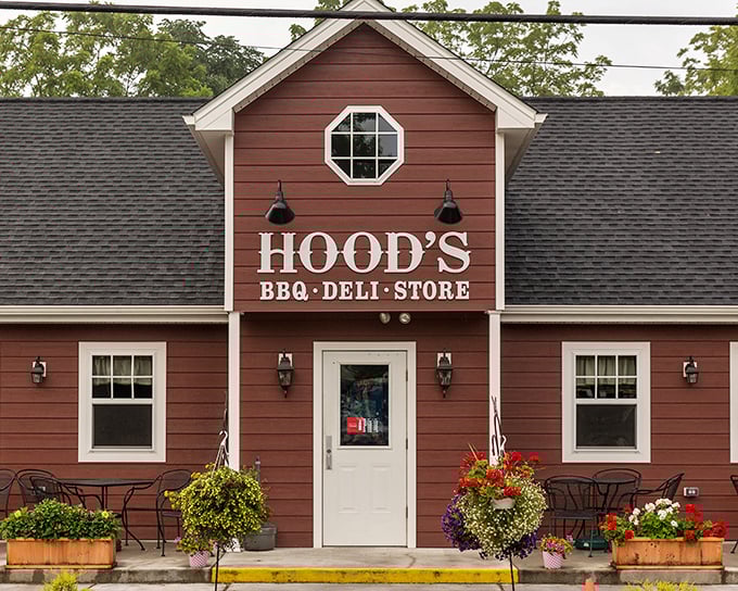 The barn-red exterior of Hood's BBQ welcomes hungry travelers like a beacon of smoky promise. Those hanging flower baskets aren't just for show&mdash;they're saying "slow down and eat something wonderful."