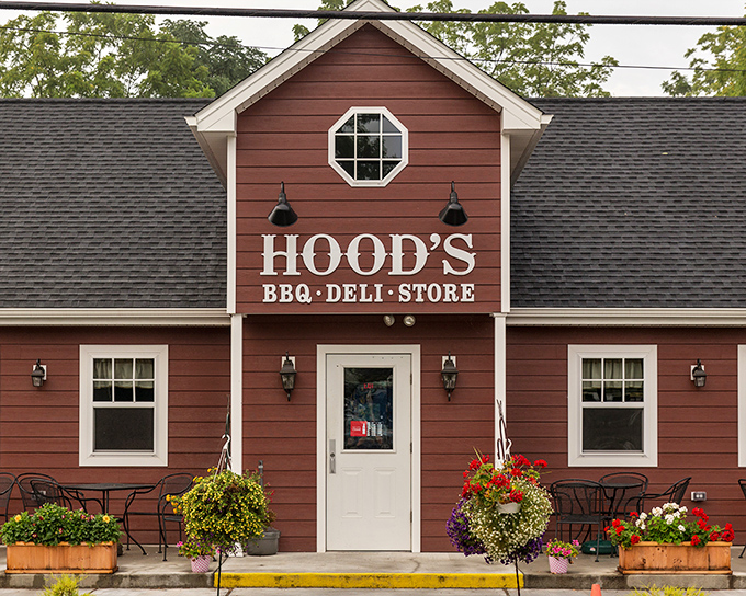 The barn-red exterior of Hood's BBQ welcomes hungry travelers like a beacon of smoky promise. Those hanging flower baskets aren't just for show&mdash;they're saying "slow down and eat something wonderful."