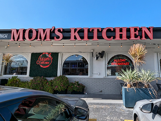 The red neon sign beckons like a lighthouse for hungry souls. Mom's Kitchen stands ready to rescue you from breakfast boredom.