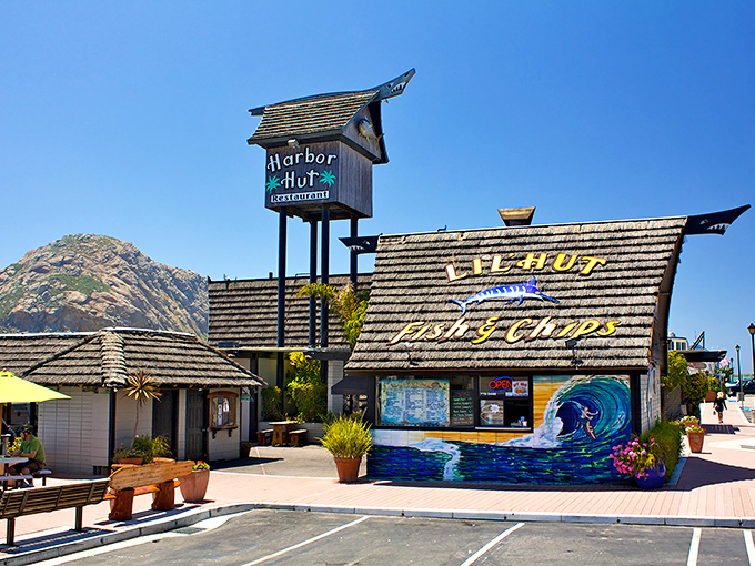 The A-frame wonder of Harbor Hut stands proudly against the California sky, its wave mural promising seafood adventures within.