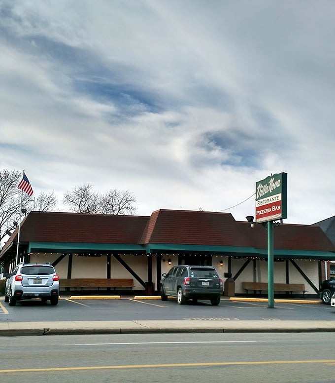 Villa Nova's charming Tudor-style exterior stands like a culinary time capsule, promising Italian delights behind its unassuming fa&ccedil;ade. The American flag waves a patriotic welcome.