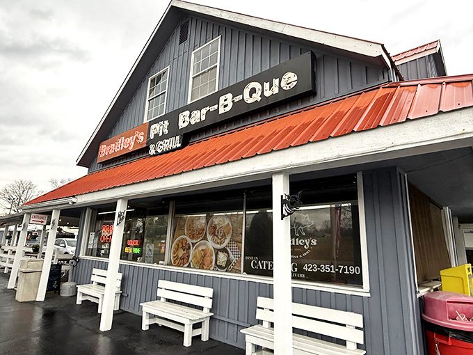 The blue building with its bright orange roof stands like a beacon of barbecue hope on the Tennessee horizon. White benches await the inevitable line of hungry patrons.